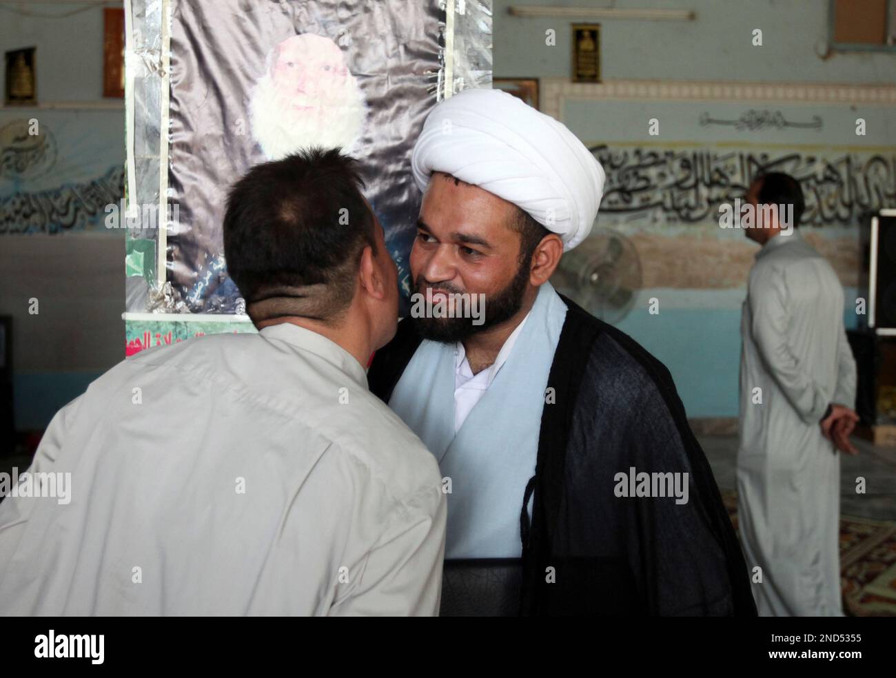 Iraqi Shiite Muslims exchange greetings after Eid prayers at Imam Ali ...