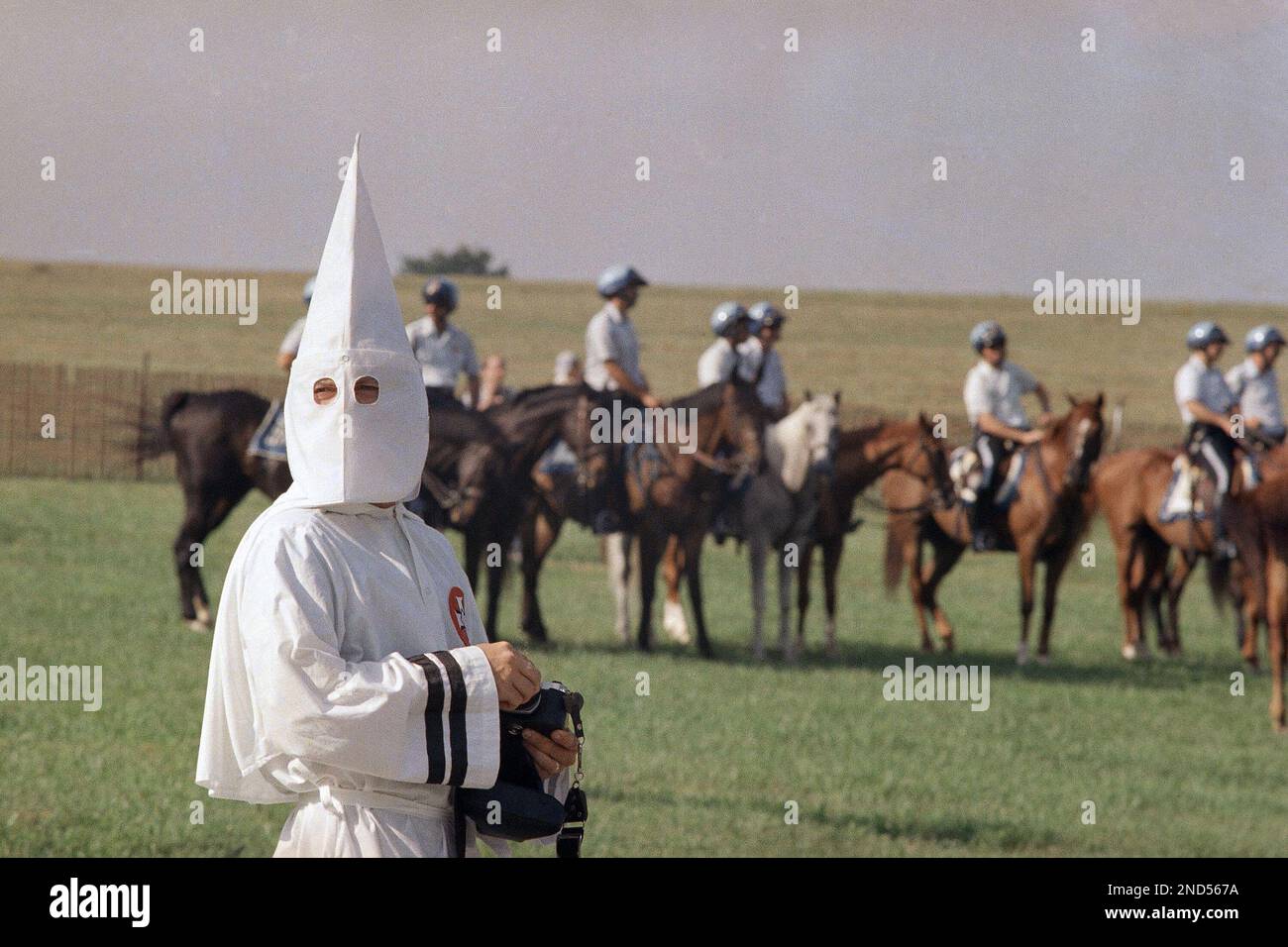 A Ku Klux Klansman watches the crowd gathered as Pennsylvania State ...