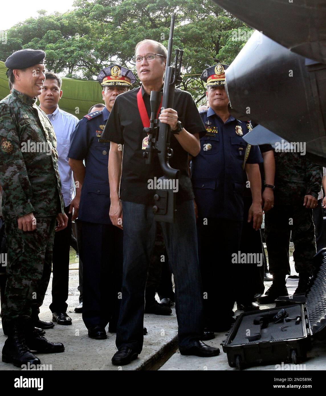Philippine President Benigno Aquino III holds a sniper's rifle during ...