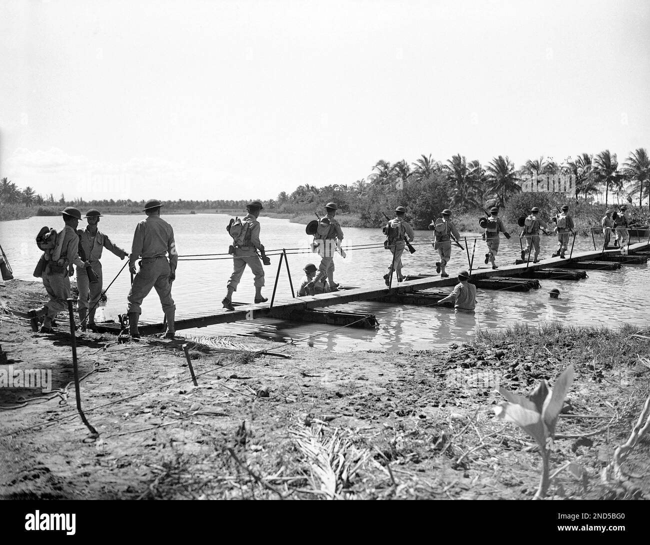 Puerto Rican soldiers of the American Army walk across bridge, which ...