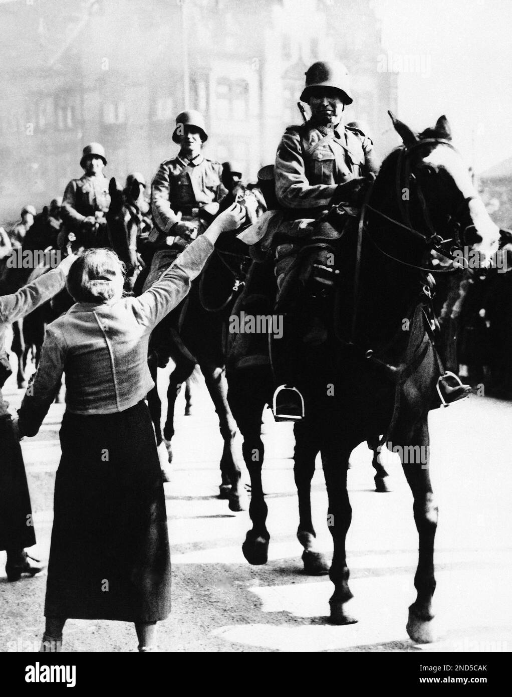 Girls bestowed flowers on cavalry soldiers on their entry into Dusseldorf on March 18, 1936 ...