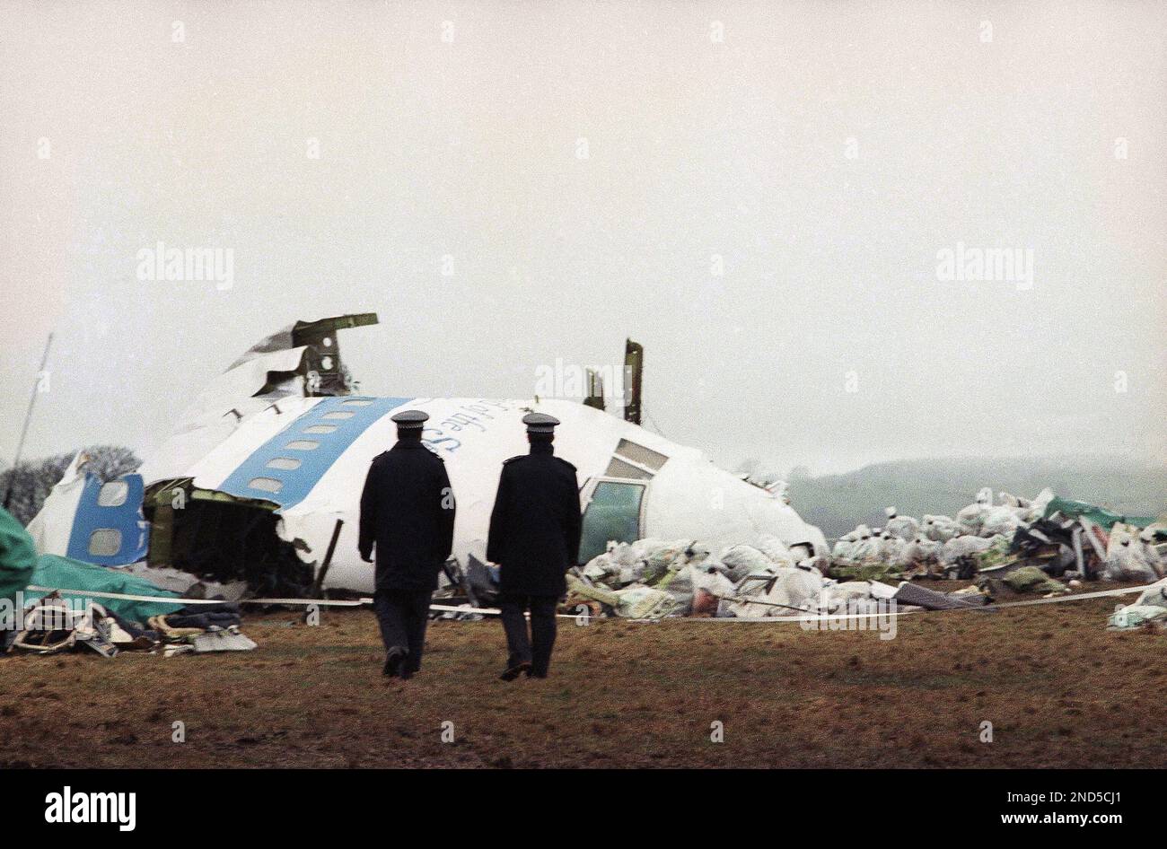 Two policemen stand guard over the nose section of the crashed Pan-Am ...