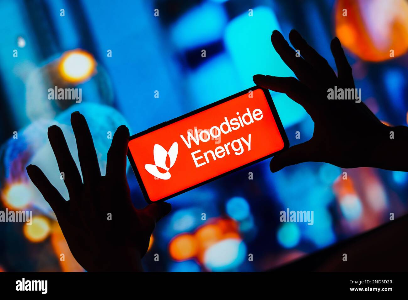 In this photo illustration, the Woodside Energy logo is seen displayed ...