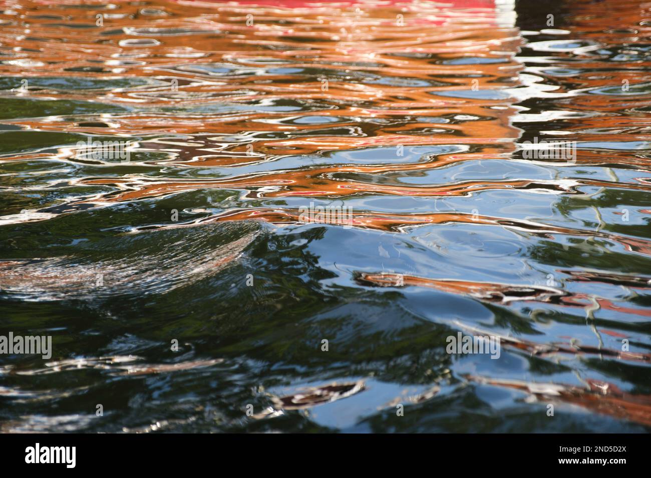 Reflections of colors on the surface of the water of a river, an orange ...