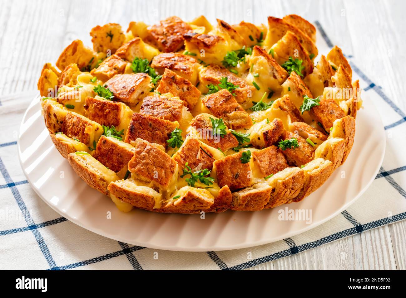 cheesy garlic bread, pull apart whole round bread on white platter on ...