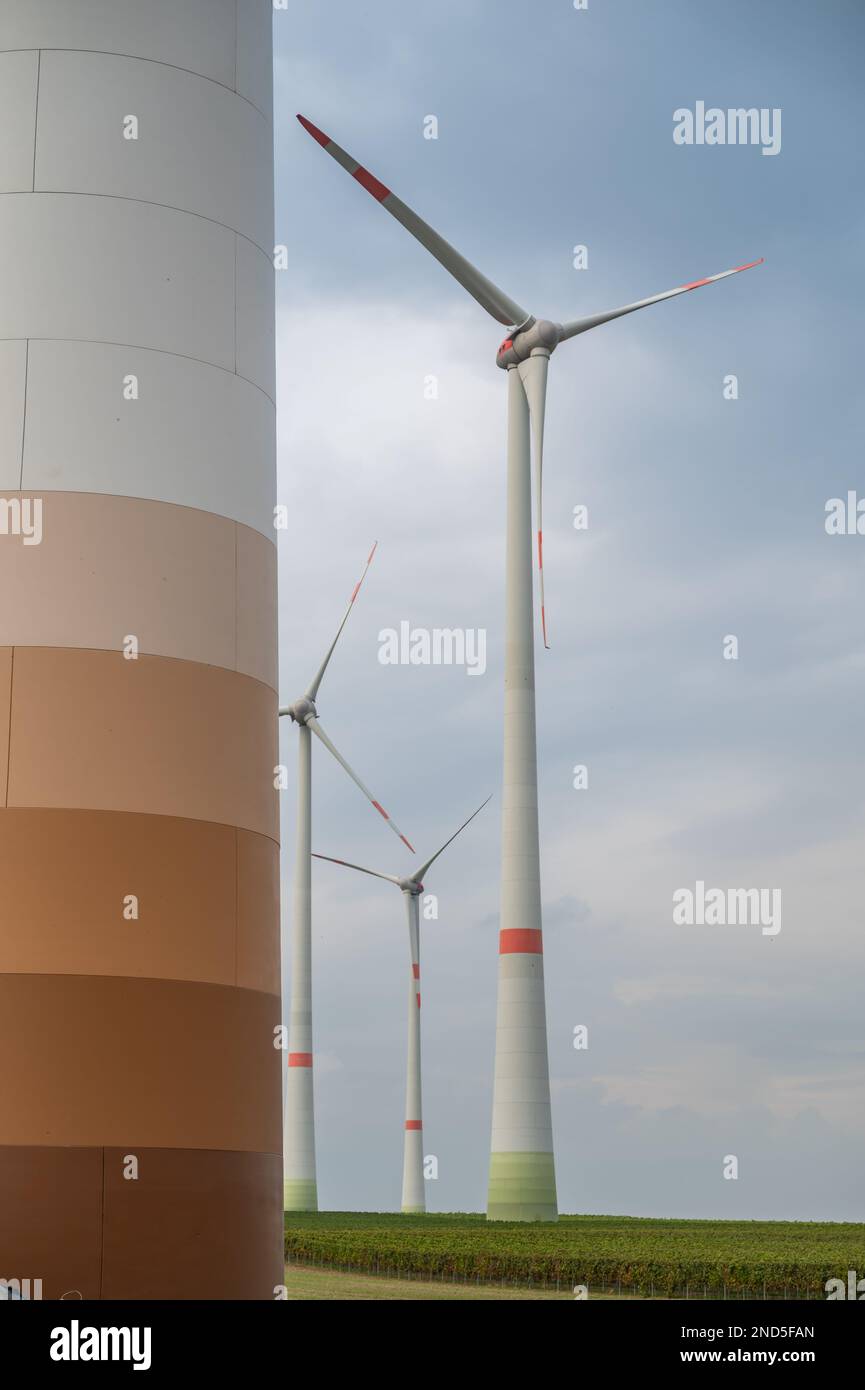 Modern renewable energy wind turbines at a wind park during cloudy day ...