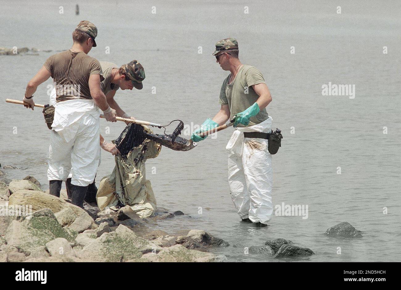 National guardsmen pick up blobs of congealed oil along the shore of ...