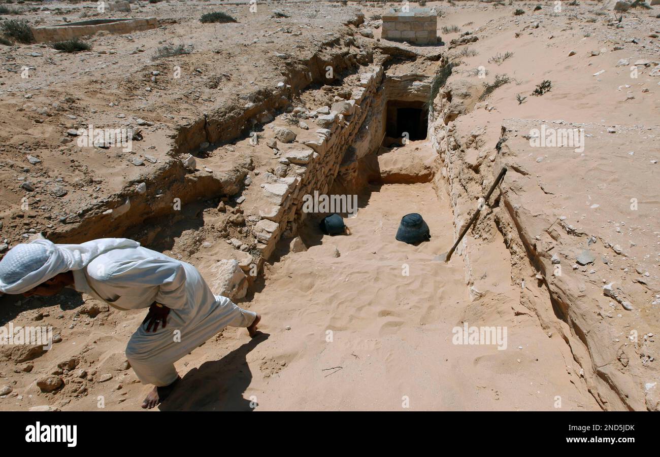 An Egyptian labor works at the entrance of an under restoration tomb at ...