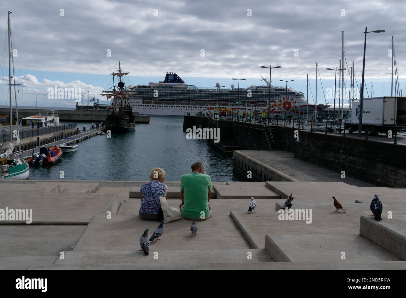 Cruise Travel - a couple sit on the dockside in Funchal Madeira ...
