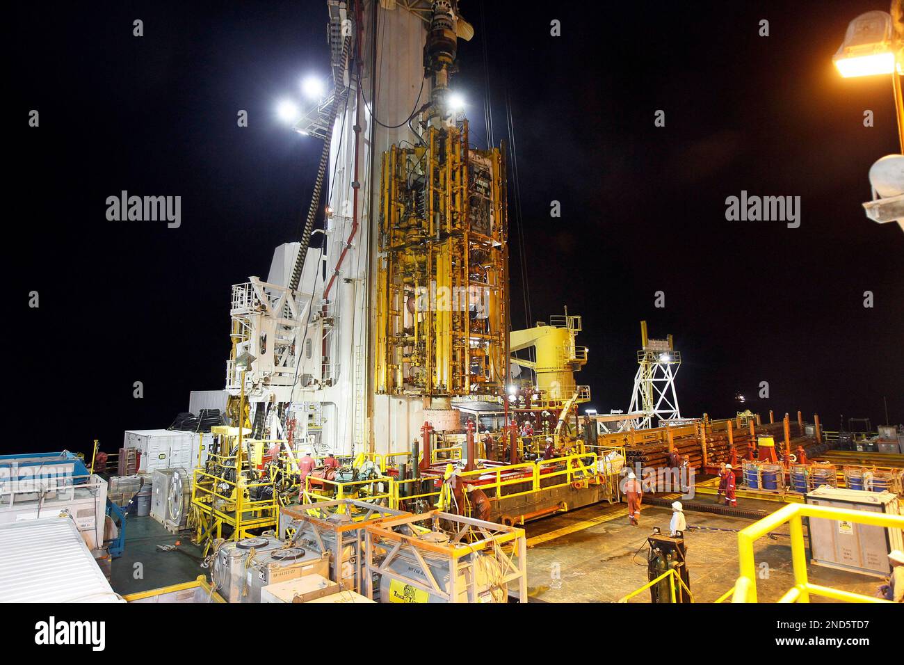 Workers watch as the Deepwater Horizon blowout preventer stack (yellow ...