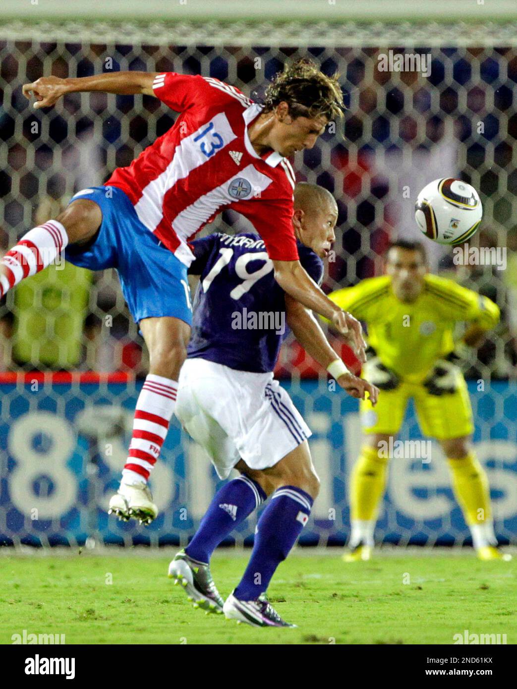 Japan's Takayuki Morimoto, center, and Paraguay's Enrique Vera, left, vie for the ball during ...