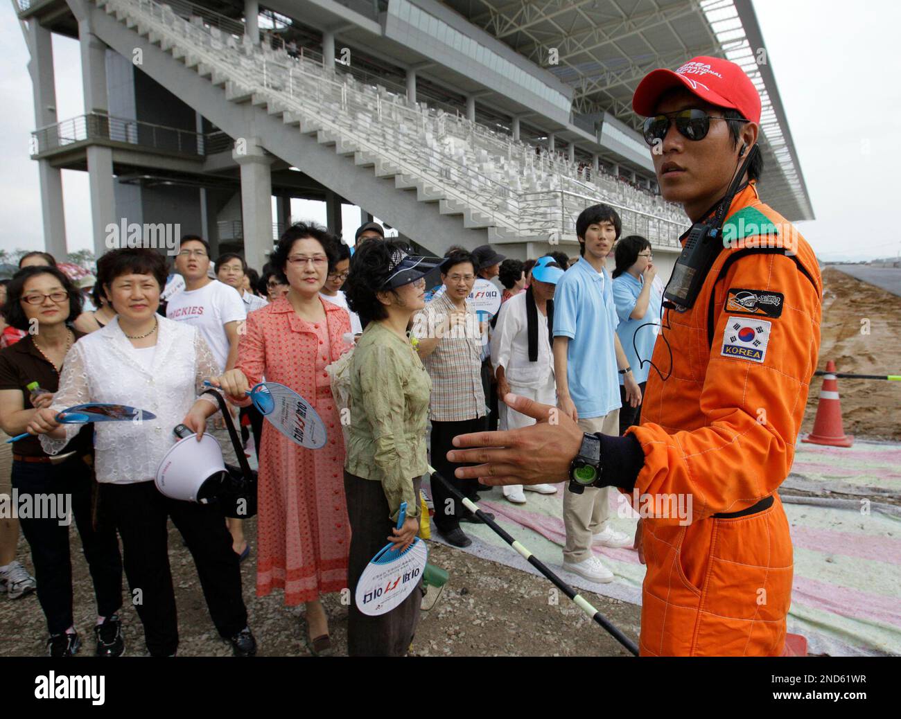 A South Korean Formula One official guides a pack of guests to a test ...