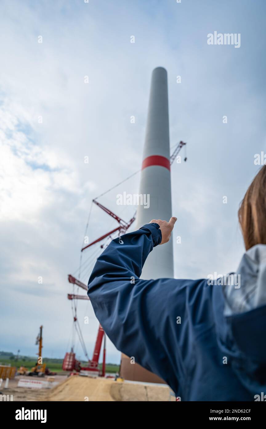 Woman with long brown hair and blue jacket pointing her finger on a ...