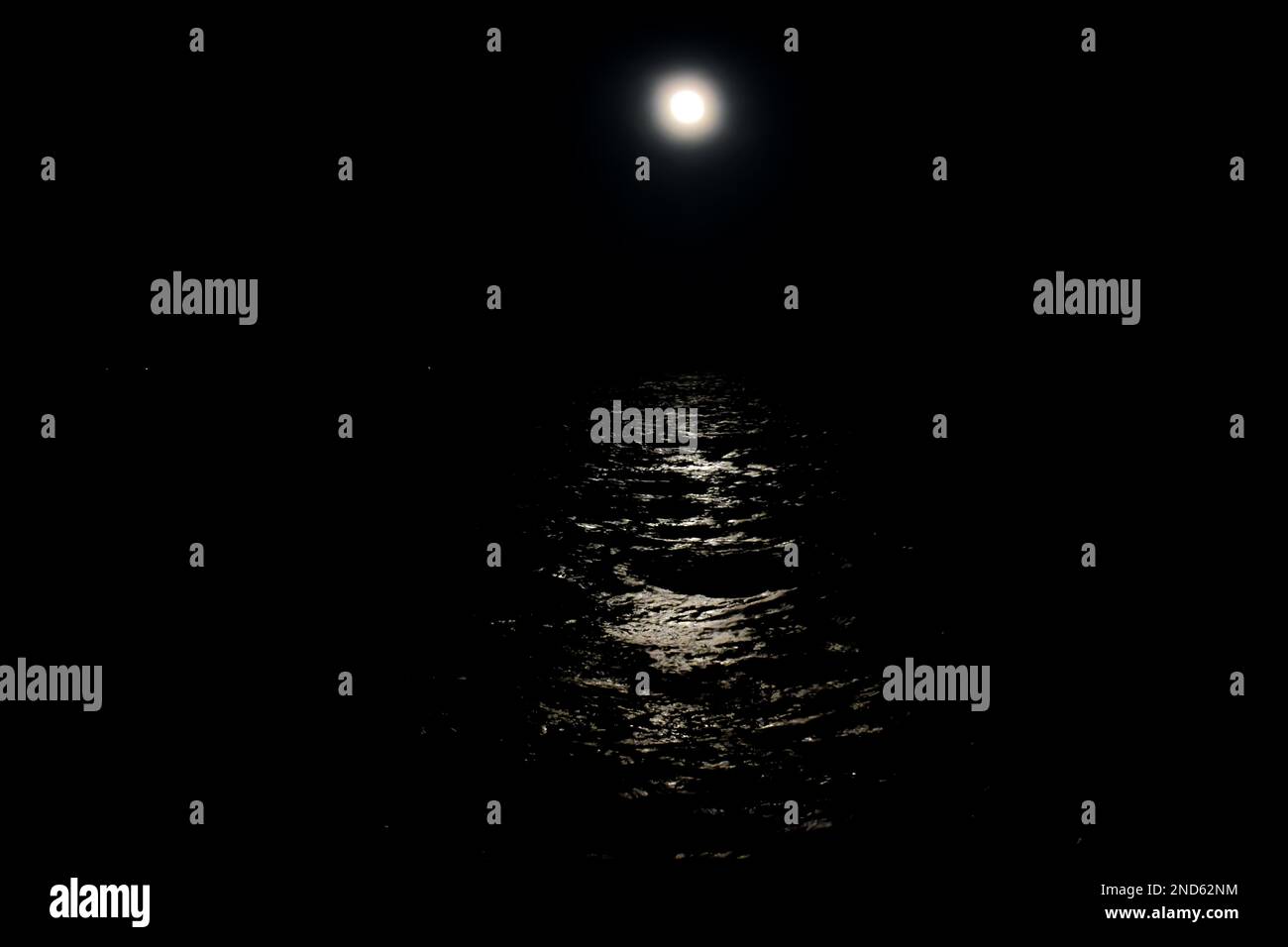 A beautiful view of the full moon in the night sky with its reflection ...