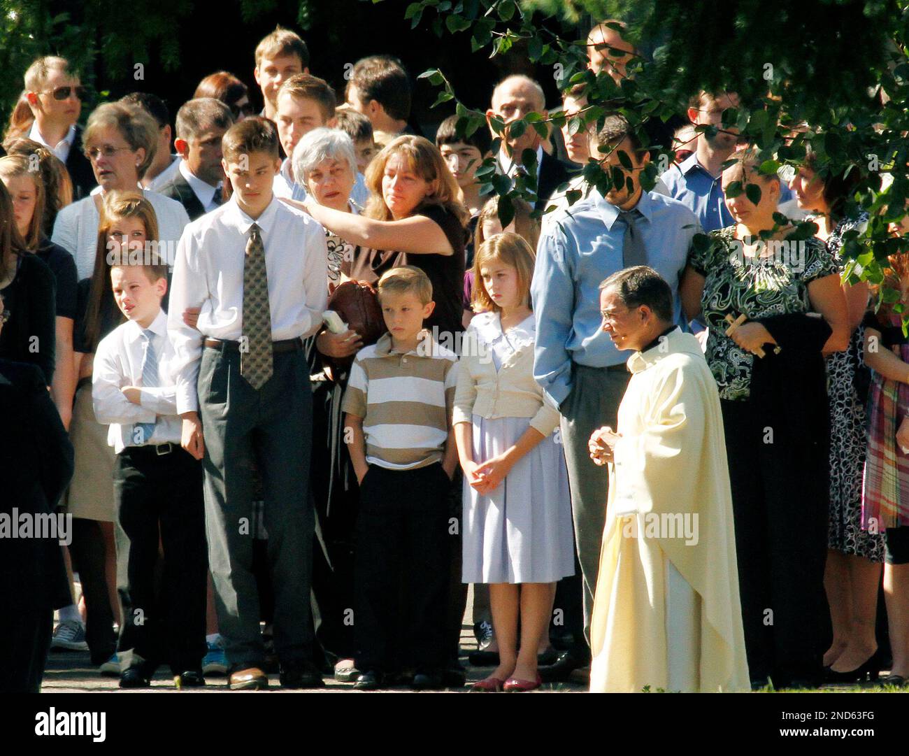 Family members and friends watch as a casket bearing the body of 13 ...
