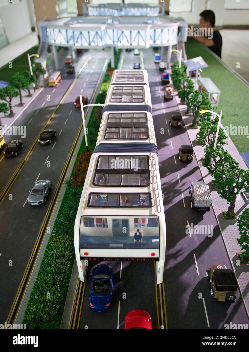 A man looks at a scale model of "Elevated High-Speed Bus", invented by ...