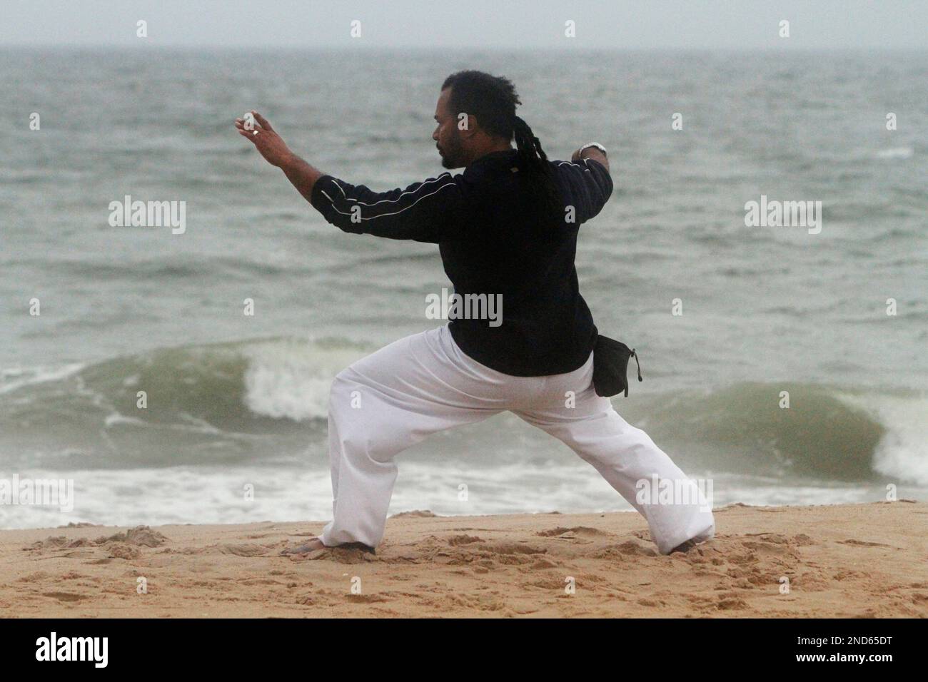 Taj Johnson does tai chi exercises on Rehoboth Beach as weather from ...
