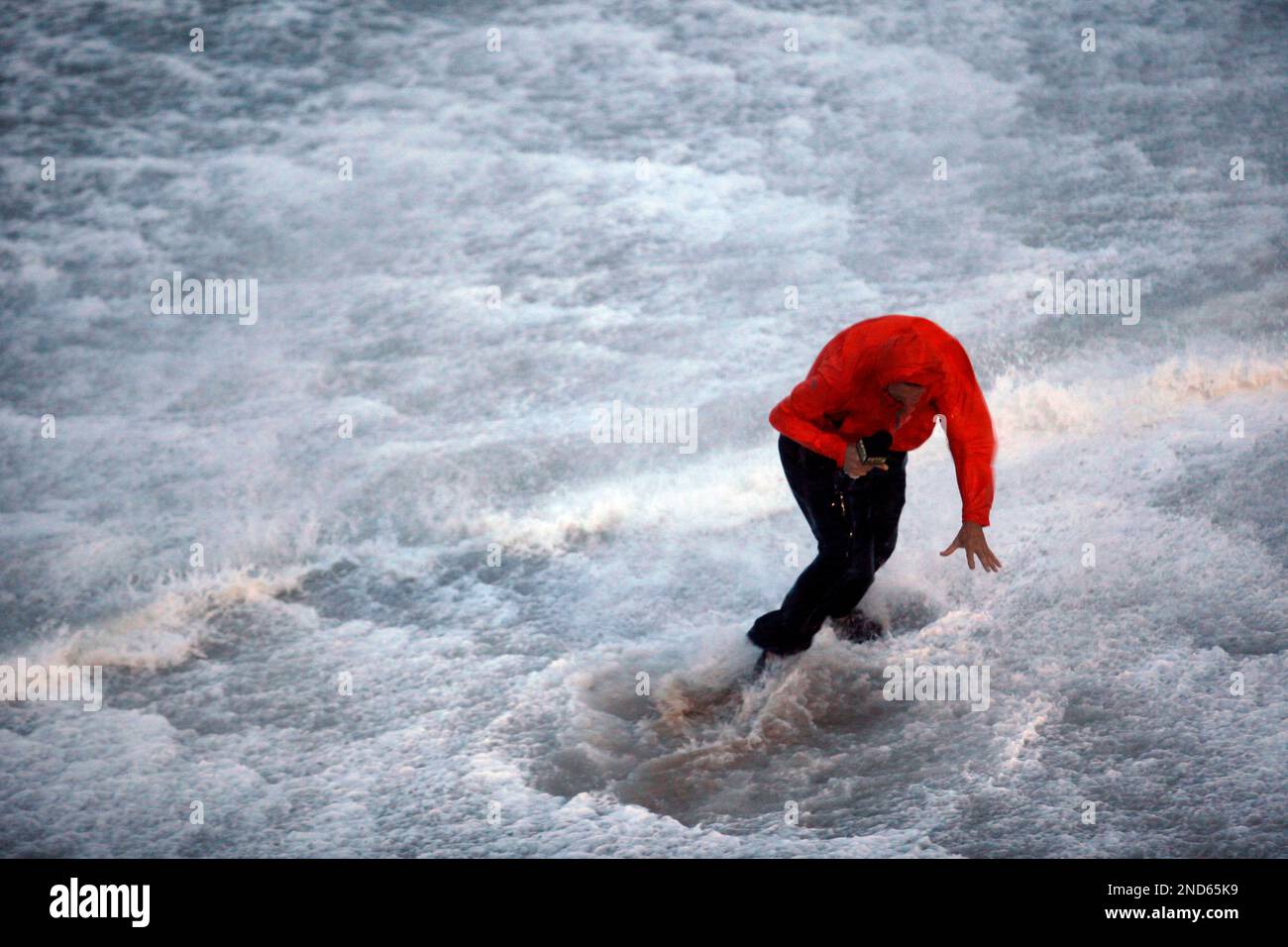 A television news reporter struggles in the surf as Hurricane Earl ...