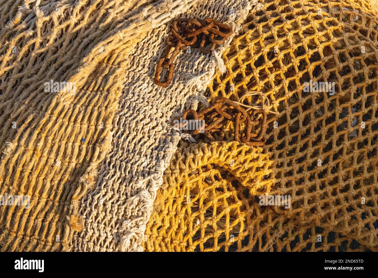 Closeup of a fishing net with a rusty chain on it Stock Photo - Alamy