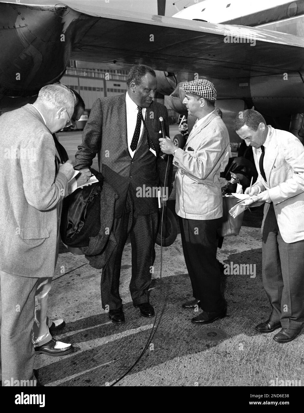 Famed baritone Paul Robeson talks to reporters at Idlewild Airport in ...