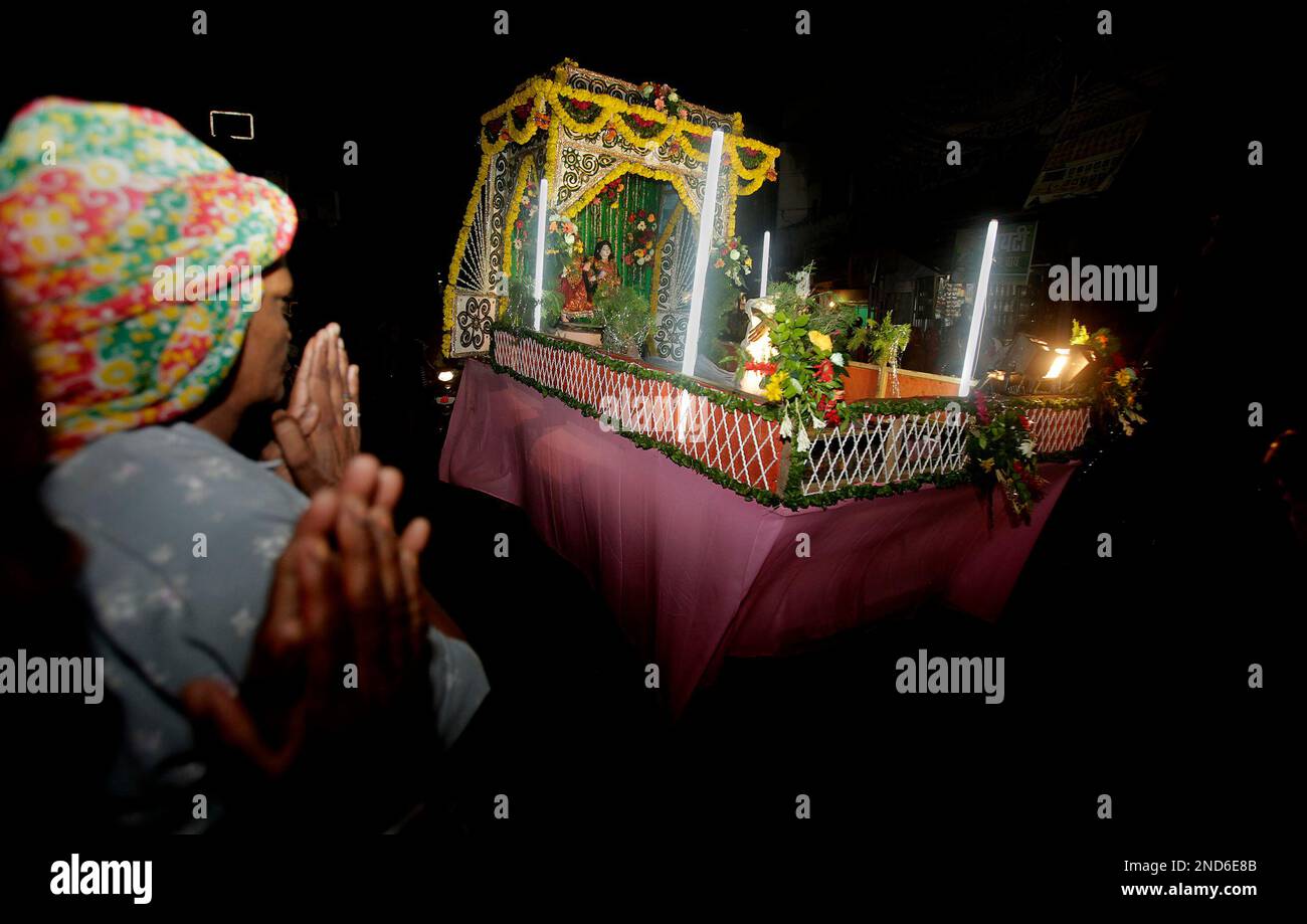 Hindu devotees offer prayers as a float carrying idols of Hindu God ...