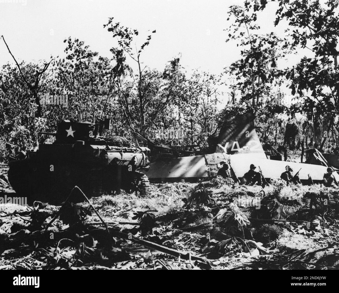 Taking cover behind a wrecked Japanese plane and with an American tank ...