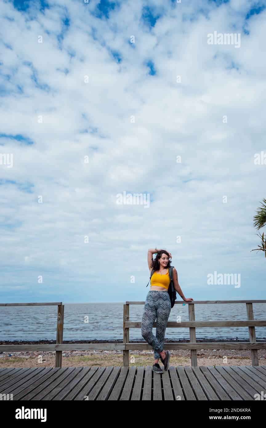 vertical image of traveler woman dressed in yellow, standing in front ...