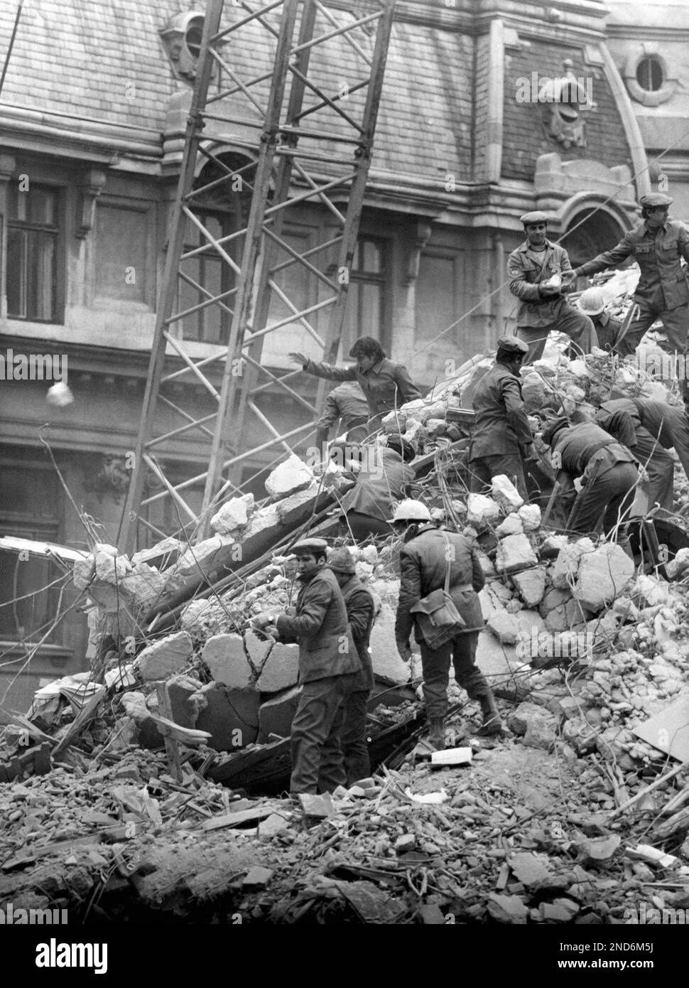 Rescue workers search for survivors in the ruins of a destroyed ...