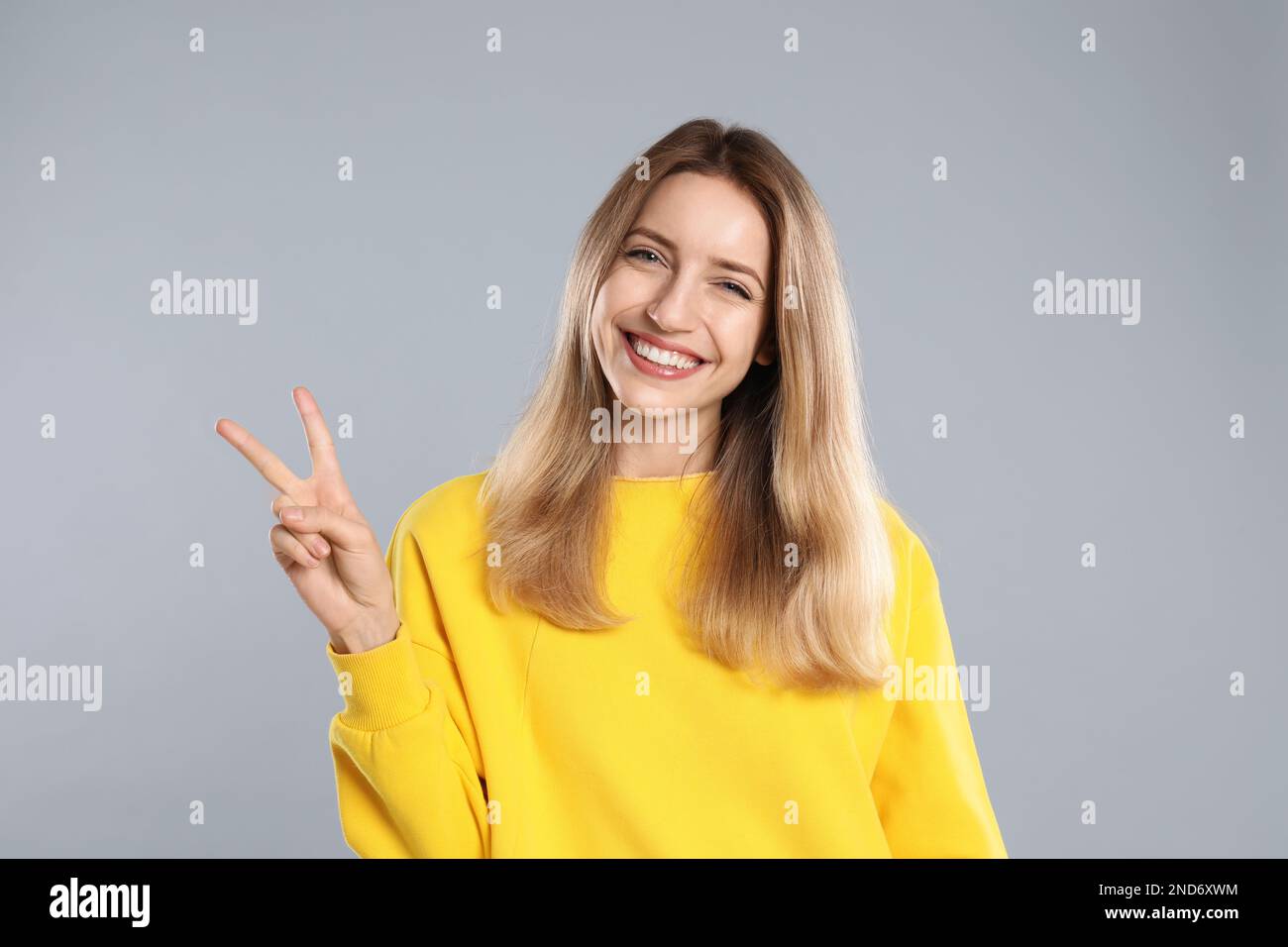 Woman showing number two with her hand on light grey background Stock ...