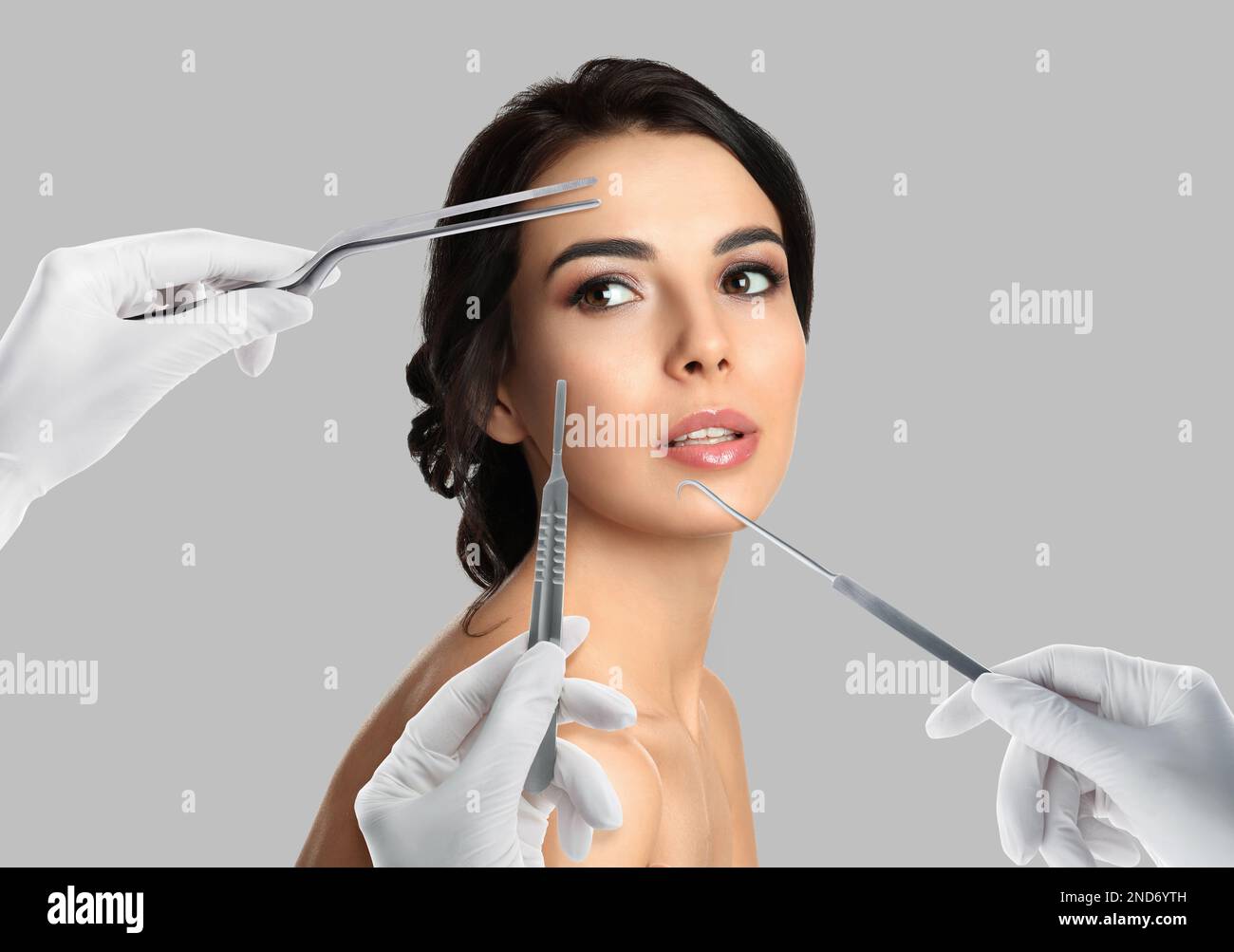 Doctors with different instruments and young woman on grey background ...