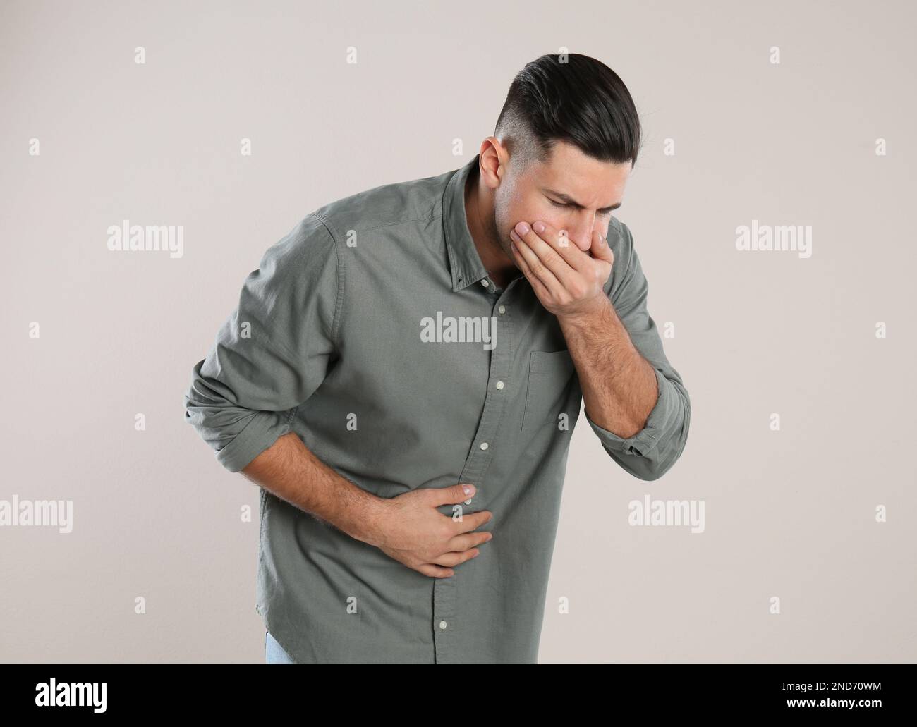 Man suffering from stomach ache and nausea on beige background. Food ...