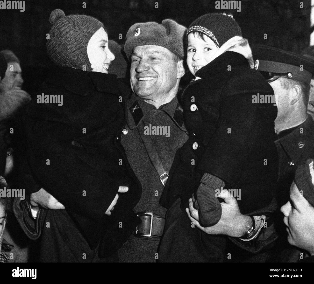 Soviet soldier embraces two young children during farewell ceremonies ...