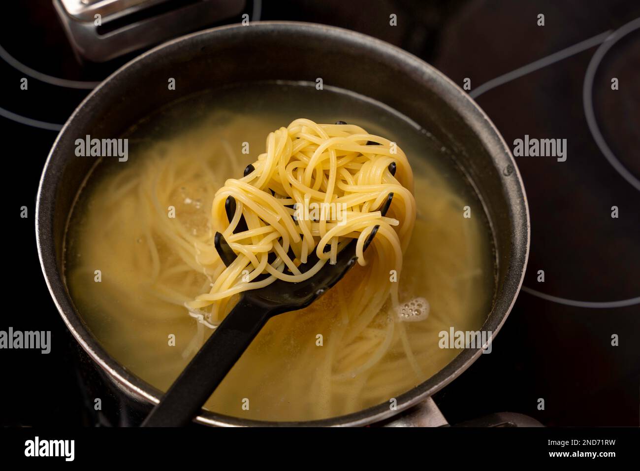 Ready cooked spaghetti is taken out of boiling water Stock Photo - Alamy