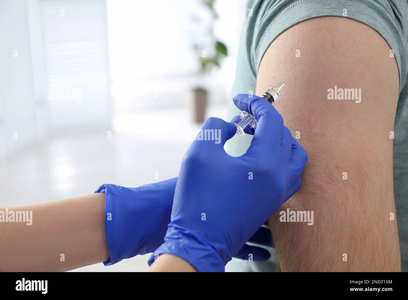 Doctor giving injection to man in hospital, closeup. Immunization ...