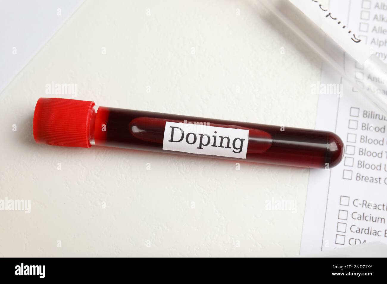 Test tube with blood sample on white table, flat lay. Doping control ...