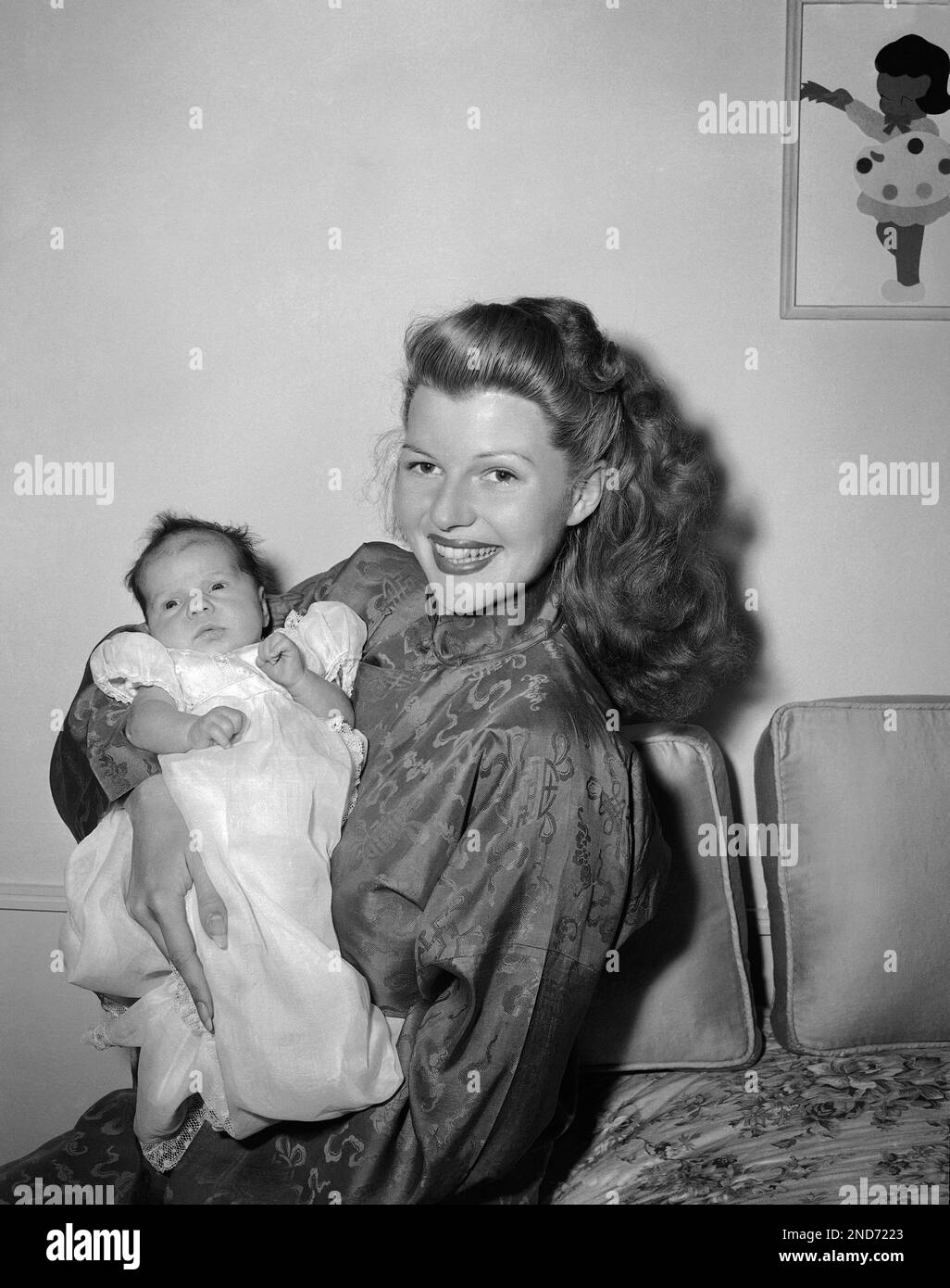 A proud mother is film star Rita Hayworth as she displays her infant ...