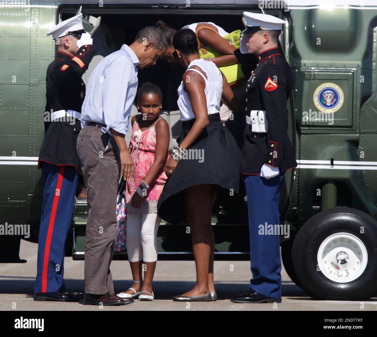 President Barack Obama and first lady Michelle Obama flank daughter ...