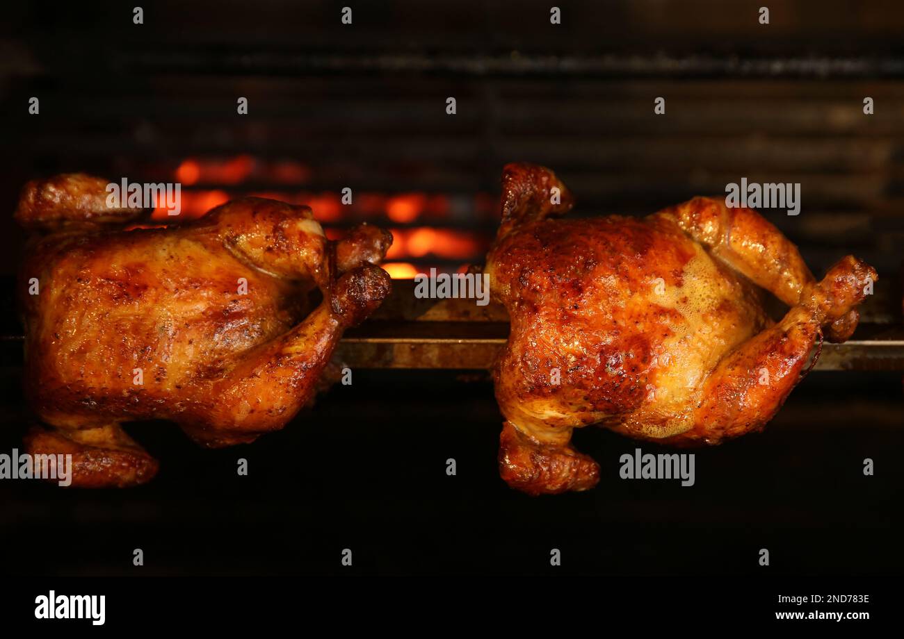 Grilling whole chickens in rotisserie machine, closeup Stock Photo - Alamy