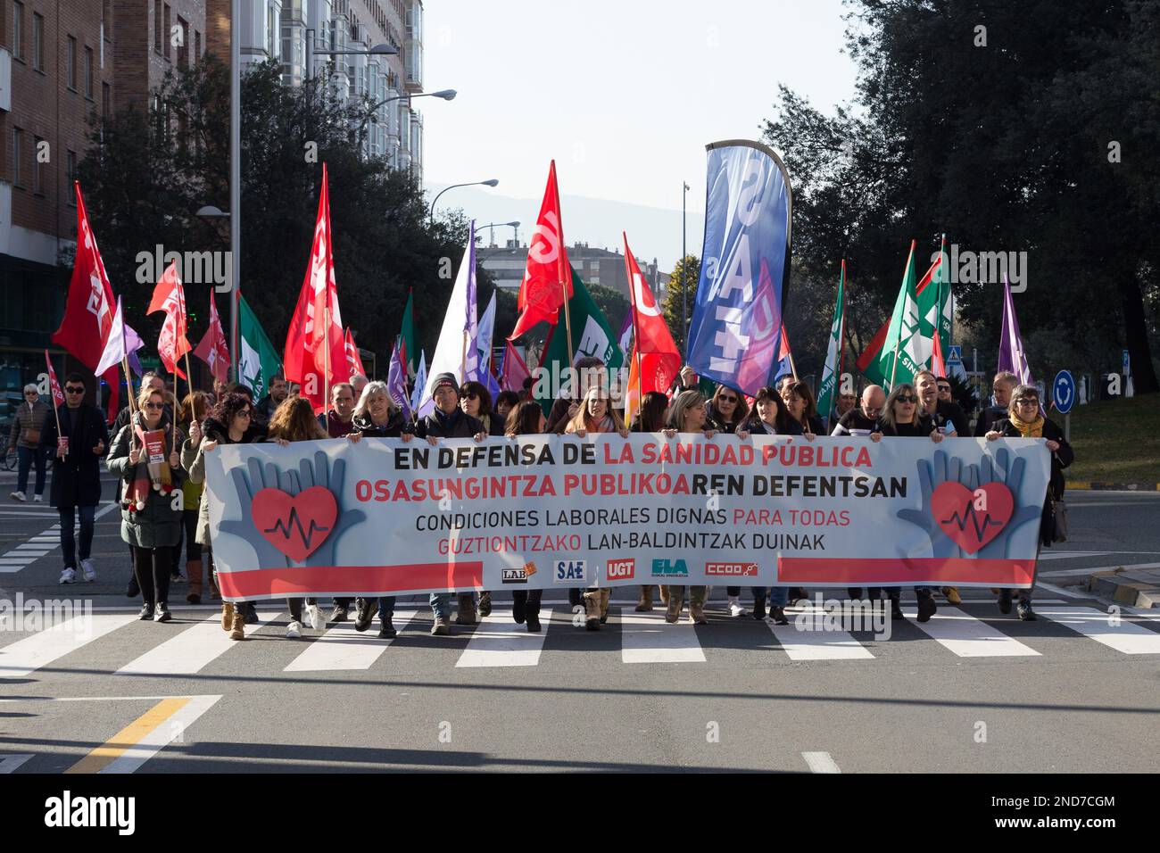 Demonstrators hold a banner and flags during the rally. Public ...