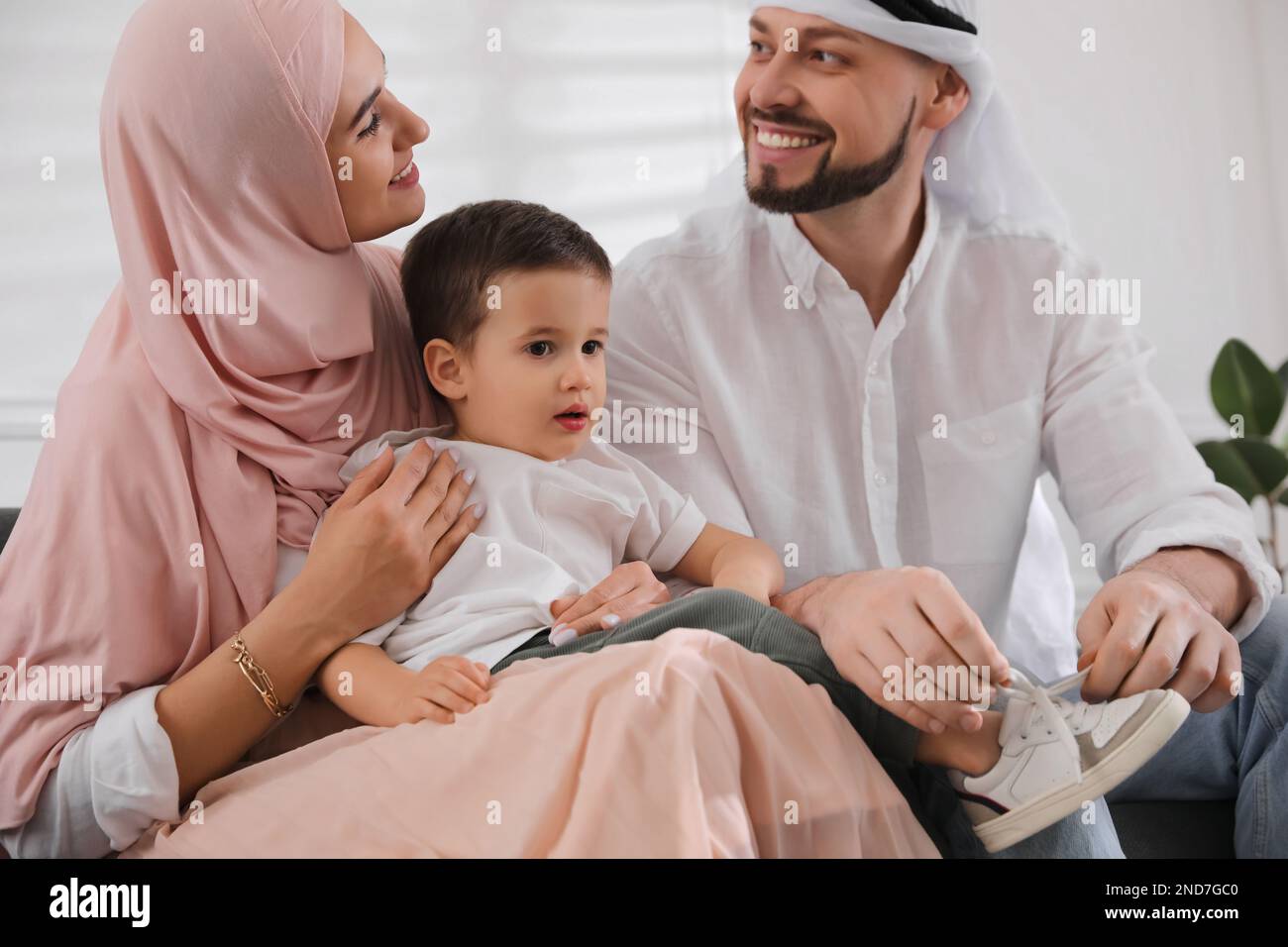 Happy Muslim family spending time together on sofa at home Stock Photo ...