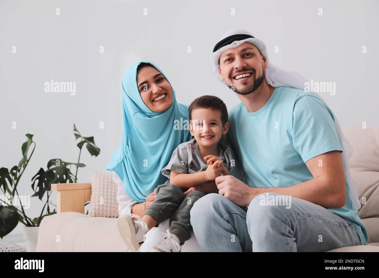 Happy Muslim family on sofa in living room Stock Photo - Alamy