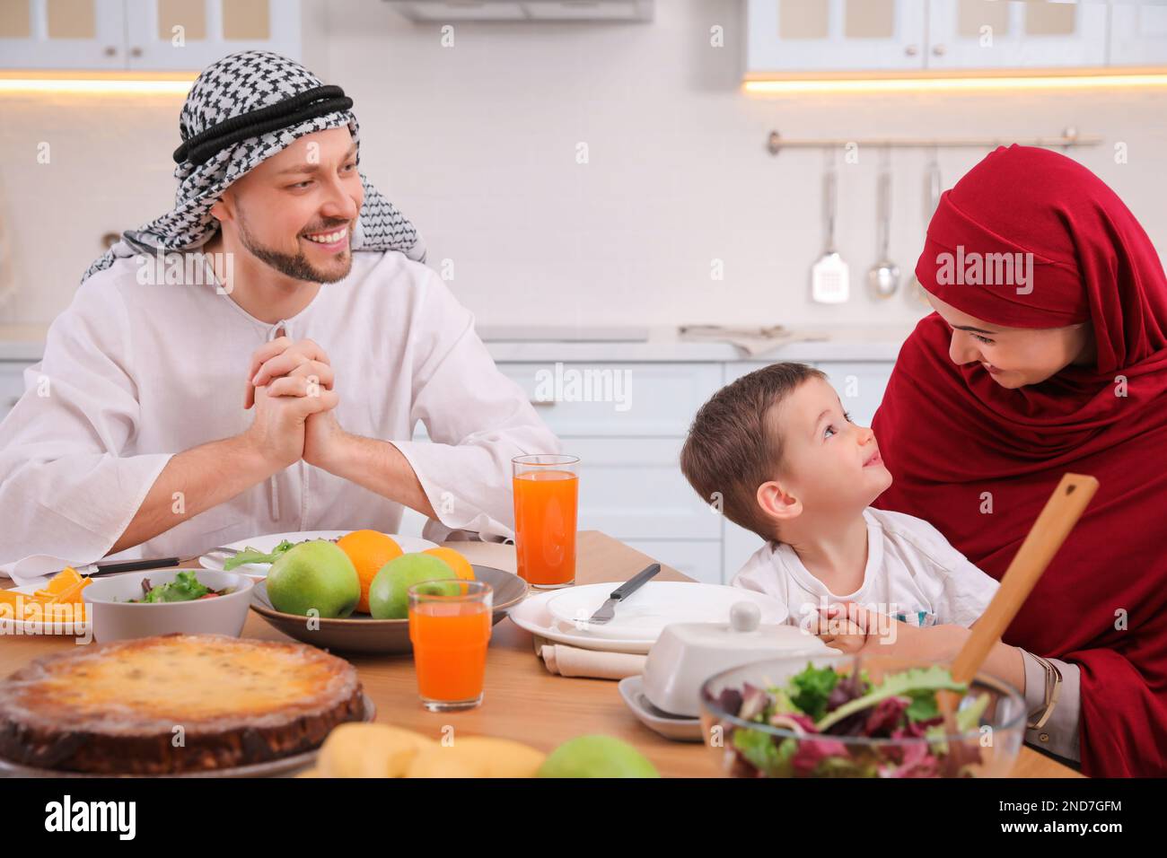 Happy Muslim family eating together at table in kitchen Stock Photo - Alamy
