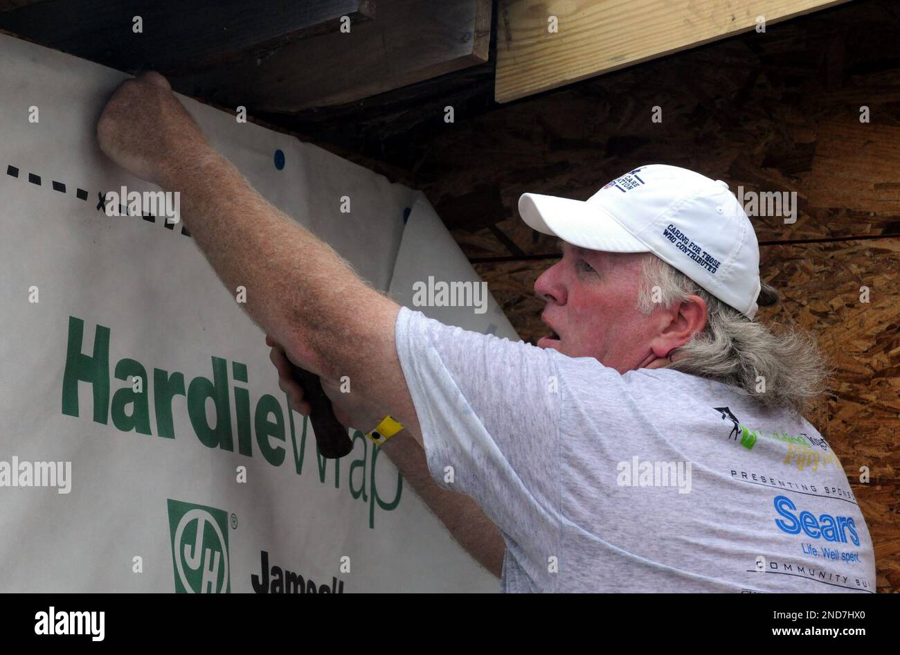 Former NFL football player Chuck Commisky works on a house as a ...