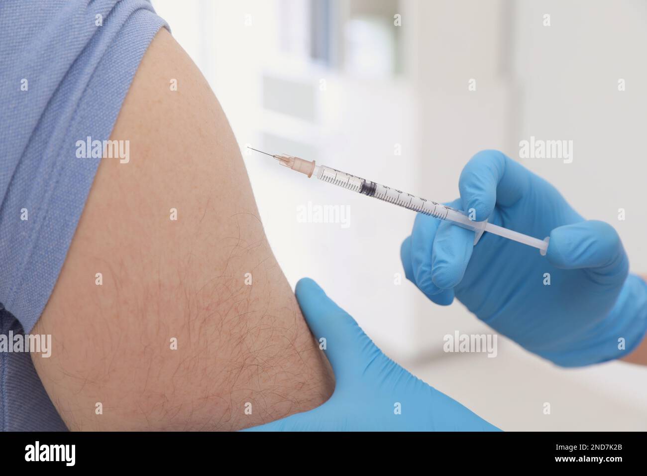 Doctor giving injection to man in hospital, closeup. Immunization ...