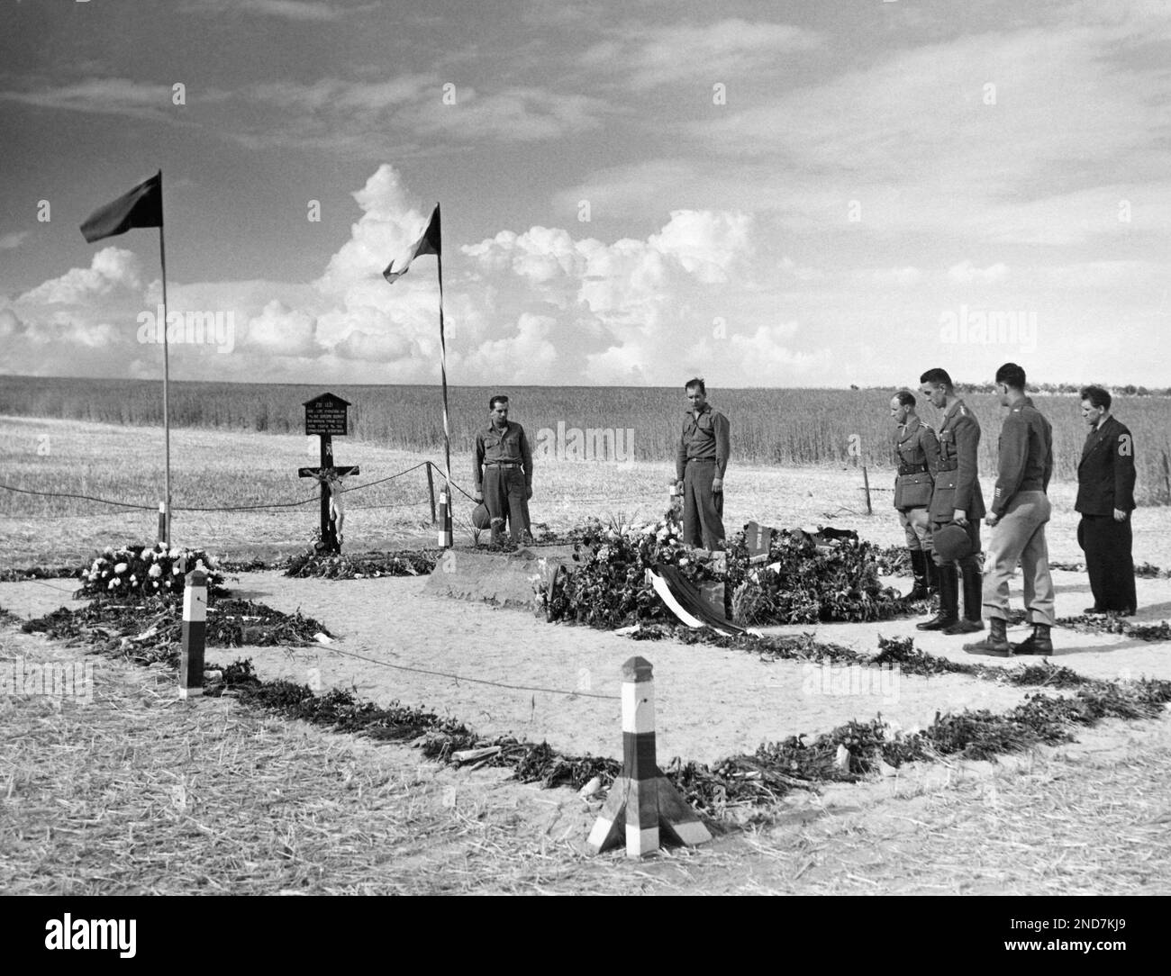 American soldiers and Czech officers gather around the grave in Lidice ...