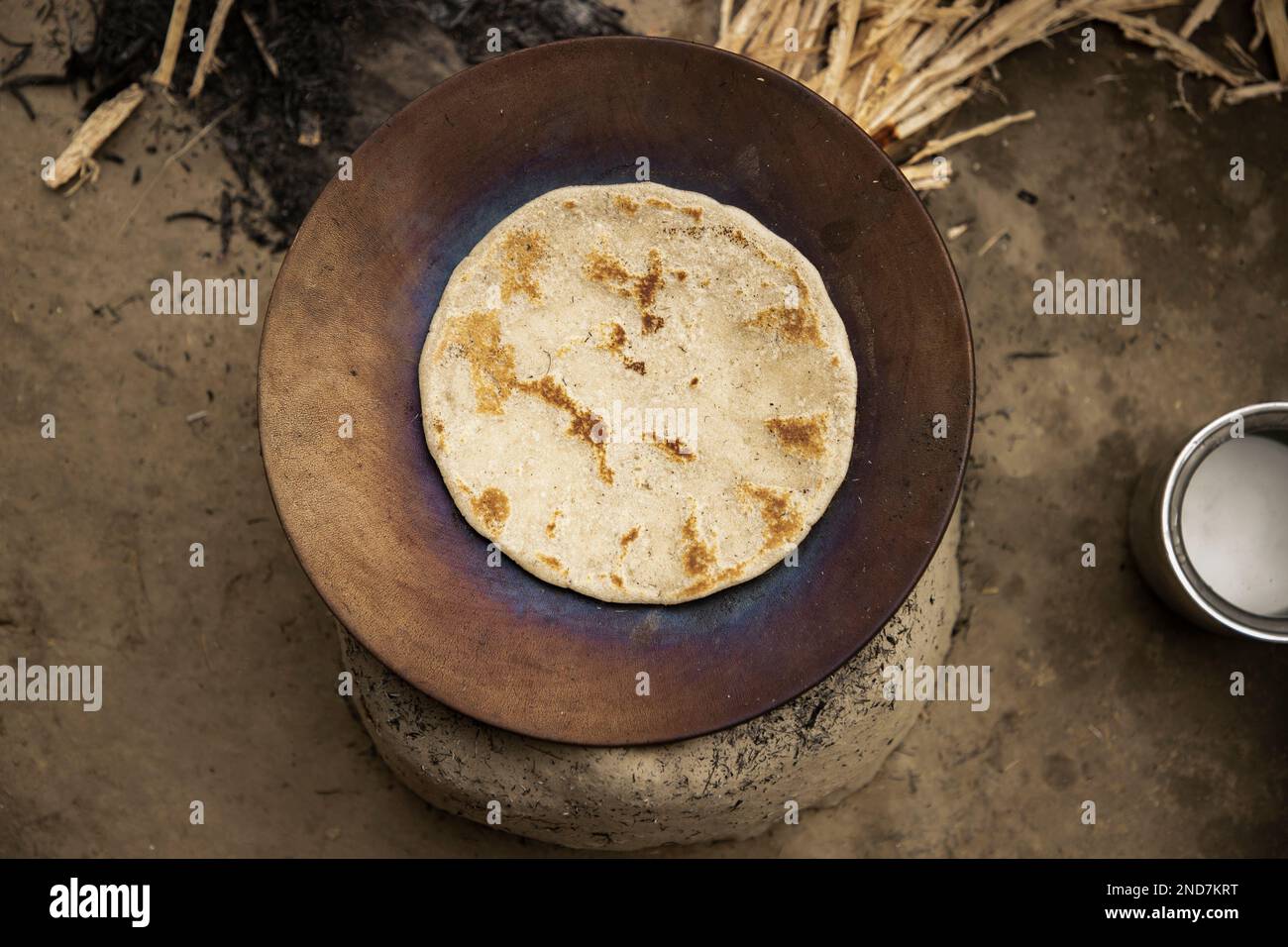 Top view of an Indian bread is cooked on the traditional mud stove ...