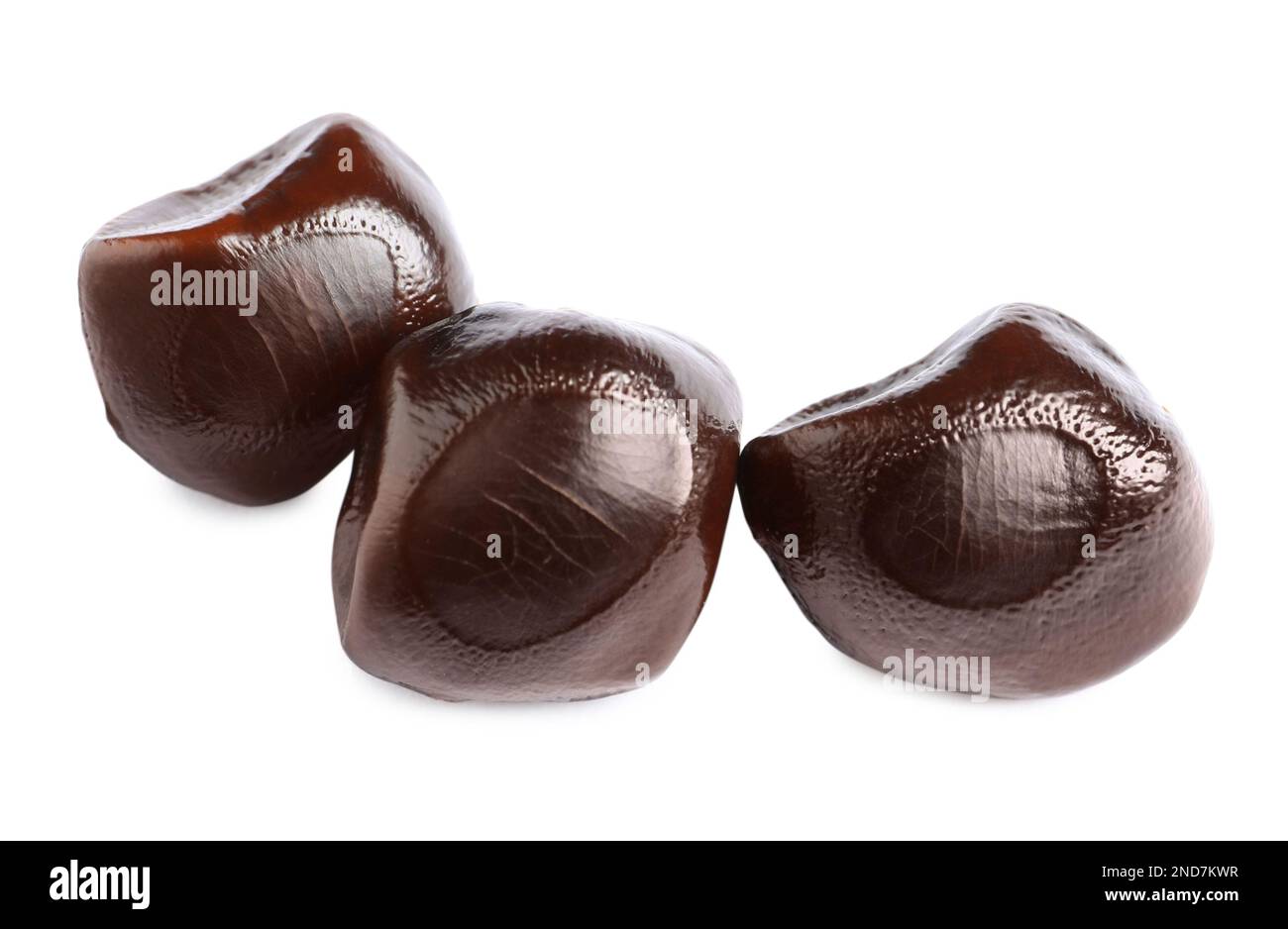 Three brown tamarind seeds on white background Stock Photo - Alamy