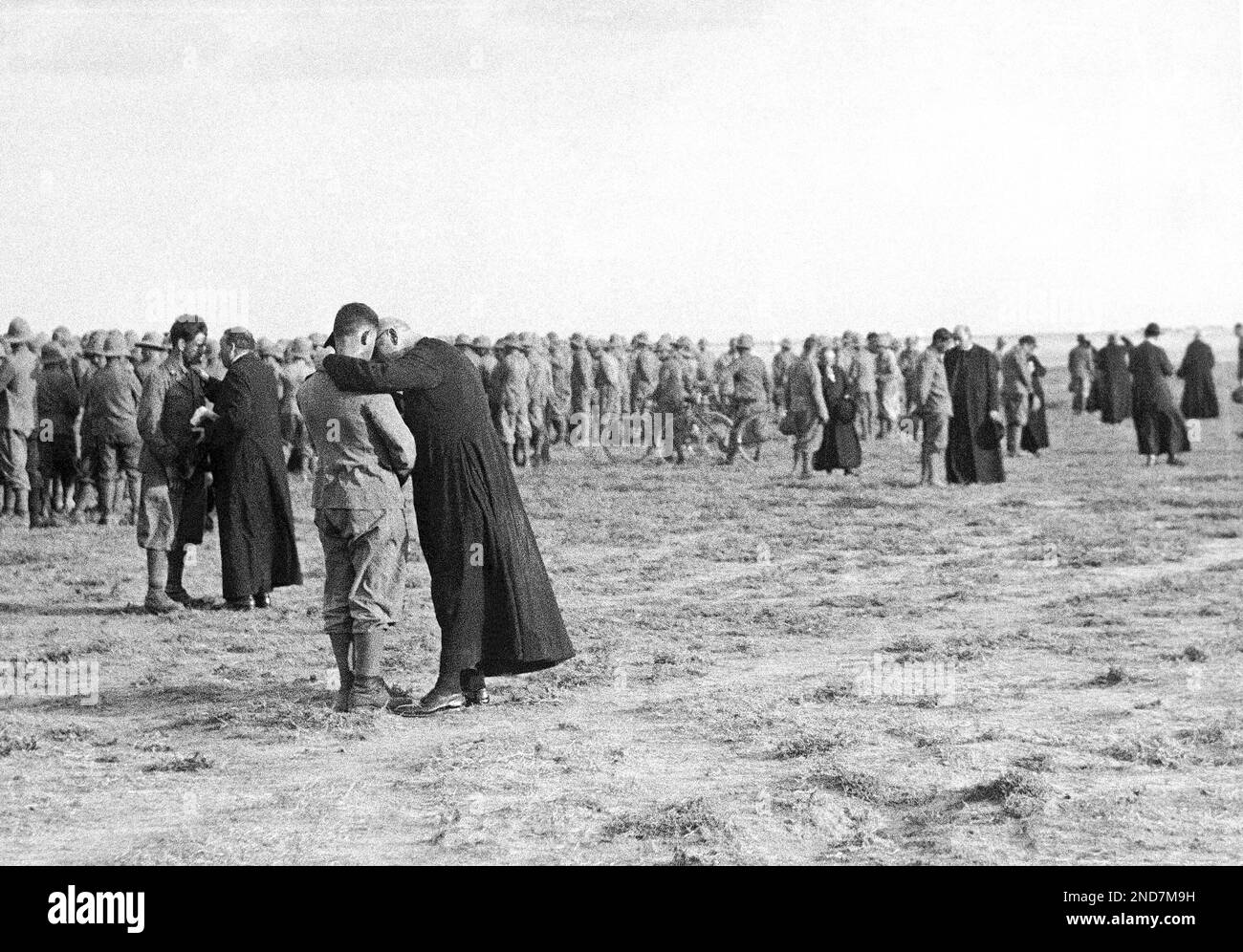 In an open field, somewhere in Africa, Catholic priests take aside ...