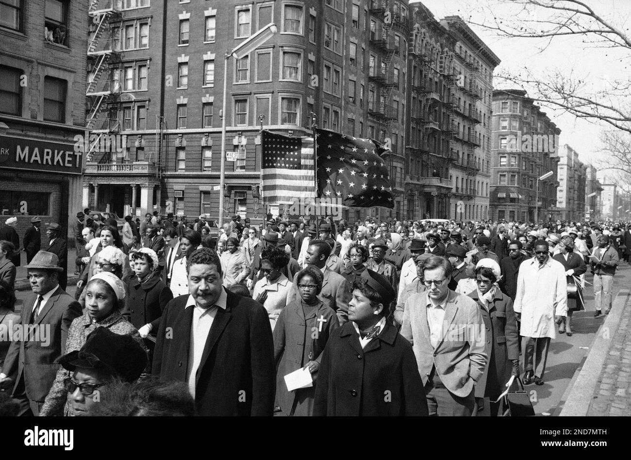 Mourners, some carrying flags, parade down Seventh Avenue near 112th ...