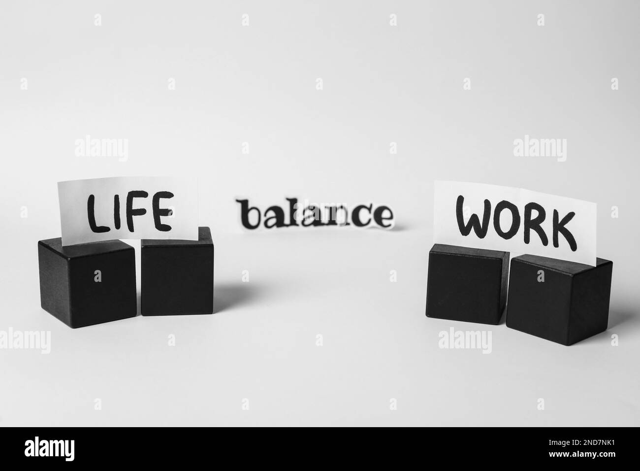 Black cubes and paper pieces with words Life, Balance, Work on white ...